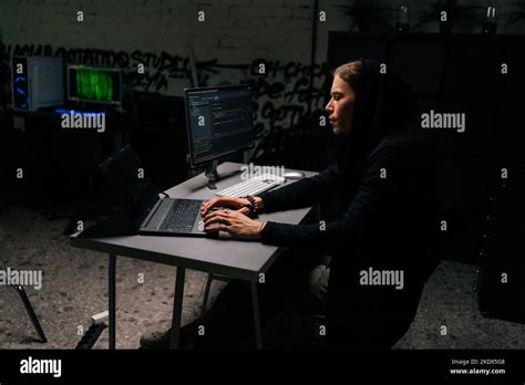 side view of dangerous hacker man in sweatshirt hacking online web site engaging hacking into