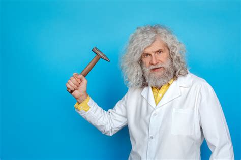 노인 착용 의사의 가운 스튜디오 고립 에 푸른 서 와 망치 찾고 카메라 심각한 곱슬 머리에 대한 스톡 사진 및 기타 이미지