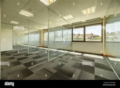 Empty Offices With Several Glass Partitions Separating Cubicles Long Windows And A Long