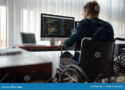 Multitasking Back View Of Young Caucasian Male Web Developer In A