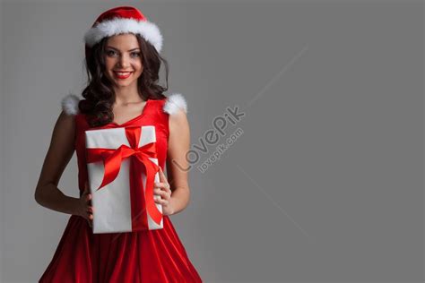 선물 상자를 들고 산타 클로스 스타일의 드레스를 입은 여자 사진 무료 다운로드 Lovepik