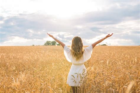 Young Woman With Her Arms Wide Spread Is Enjoying In The Sunny Summer