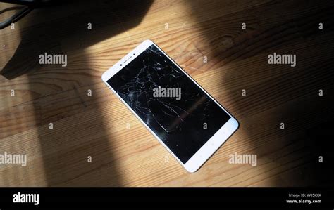 Xiaomi Mi Max Smartphone With Broken Screen Matrix Lies On Wooden Table Sunlight Emphasizes