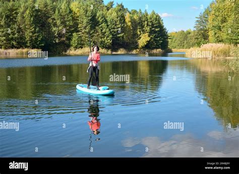 Active Woman Paddling Sup Board On Beautiful Lake Autumn Forest