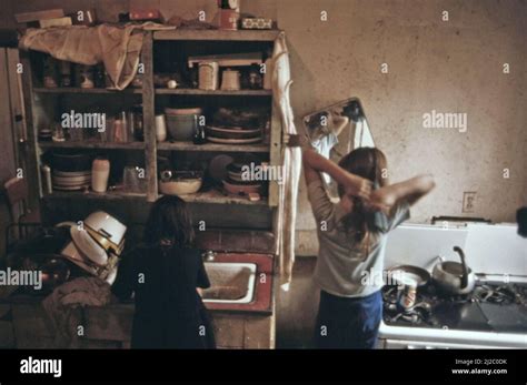 A Pre Teen Girl Age 12 Washes Dishes In The Kitchen Of Her House In