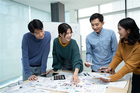 아시아 팀 Ux 개발자와 Ui 디자이너가 현대 사무실에서 고객 브리핑과 색상 코드가 있는 테이블에 모바일 앱 인터페이스 와이어프레임 디자인에 대해 브레인스토밍합니다 Gui