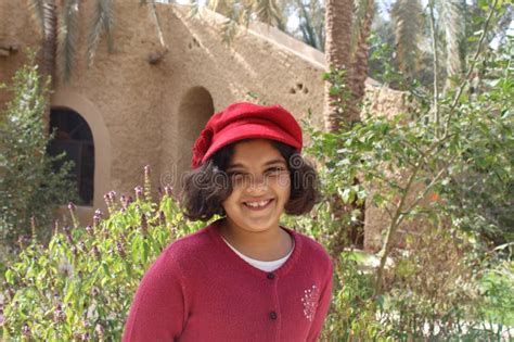 Young Girl Wearing A Red Headpiece And Smiling Under The Sunlight Of