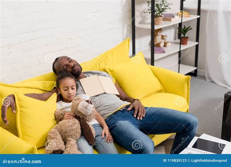 Father And Daughter Sleeping Together On Couch After Stock Image
