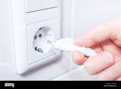 Female Hand Is Holding And Connecting An Electrical Plug In A Wall Socket Stock Photo Alamy