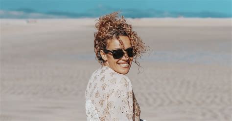 여름 휴가 휴가에 해변에서 카메라를 보며 하루를 즐기는 쾌활한 여성 관광객 웃고 야외 레저 활동을 즐기는 성인 여성의 초상화 행복의 개념 사진 Unsplash의