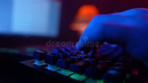 Man Using Computer Keyboard Code Website In Neon Lighting Hacker And