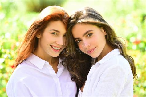 Two Happy Pretty Women Posing Together While Looking At The Camera Over