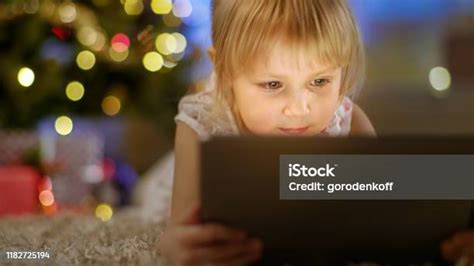 그녀의 손에 태블릿 컴퓨터와 귀여운 어린 소녀는 크리스마스 트리 아래 카펫에 거짓말 4k해상도에 대한 스톡 사진 및 기타 이미지 4k해상도 가정의 방 갈런드 텍사스