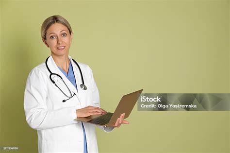 연한 녹색 배경에 청진기와 노트북이 있는 의료복을 입은 의사 텍스트 공간 45 49세에 대한 스톡 사진 및 기타 이미지 45 49세 건강관리와 의술 나이 Istock