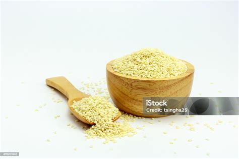 나무 그릇에 숟가락 흰색 배경에 흰색 참 깨 씨앗 흰색 배경 위에 절연 구성입니다 갈색에 대한 스톡 사진 및 기타 이미지