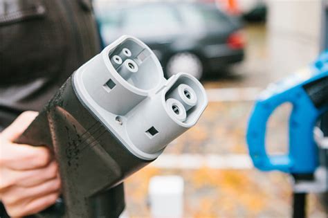 드라이버 전기 자동차를 충전 하는 케이블을 선택 합니다 전 세계에 걸쳐 확산은 전송의 현대적이 고 환경 친화적인 모드입니다 가솔린에 대한 스톡 사진 및 기타 이미지 Istock