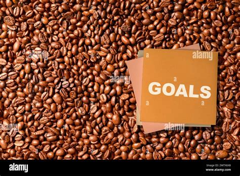 Stack Of Notes With Goals Text And The Coffee Beans Background