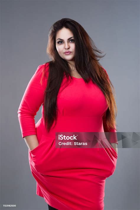 빨간 드레스 회색 배경에 긴 머리를 가진 뚱뚱한 여자에 있는 갈색 머리 플러스 크기 패션 모델 몸 긍정주의에 대한 스톡 사진 및