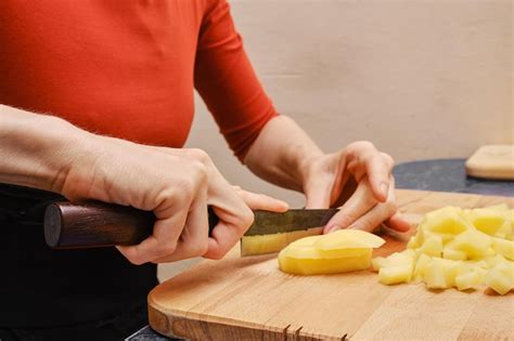 Premium Photo Cropped Close Up Shot Of A Woman Cutting Potatoes On A