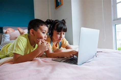 헤드폰과 노트북을 사용하는 아시아 어린이 여동생은 침실에서 교사에게 어린 형제 화상 통화로 온라인으로 공부합니다 6 7 살에 대한 스톡 사진 및 기타 이미지 Istock