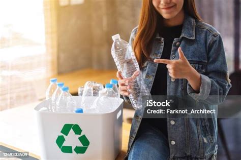 재활용 컨셉을 위해 테이블에 쓰레기통이 있는 플라스틱 병을 들고 손가락을 가리키는 여성 0에 대한 스톡 사진 및 기타 이미지 0 감소 개념 Istock