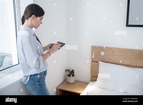 Female Operating A Remote Control In The Bedroom Stock Photo Alamy