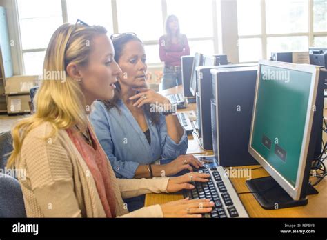 Two Women Searching Computer Data For Books In Library Stock Photo Alamy