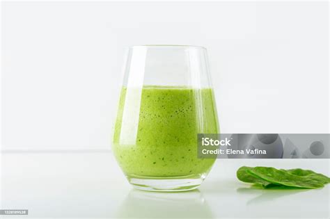 시금치 사과 오이 두유의 녹색 스무디가 흰색 배경에 유리로 들어 있습니다 가정 요리 비건 건강 해독 식사 식이 및 Weght 손실 음료 건강한 생활방식에 대한 스톡 사진 및