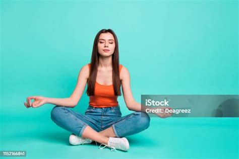 전체 길이 몸 크기 사진 아름 다운 그녀의 그녀의 여자 주말 앉아 바닥 교차 다리 로터스 포즈 눈 폐쇄 명상 착용 캐주얼 오렌지