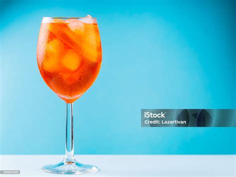 Aperol Spritz 칵테일은 파란색 배경에 유리로 되어 있습니다 오렌지와 얼음 조각을 곁들인 클래식 이탈리안 식전주 Aperol Spritz 칵테일 복사 공간 와인잔에
