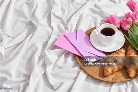 아침 축하 행사는 따뜻한 커피 한 잔 바삭바삭한 크루아상 나무 쟁반에 배열된 생생한 분홍색 튤립을 특징으로 하며 침대에서 어머니의 날 아침 식사를 하기에 적합합니다 0명에