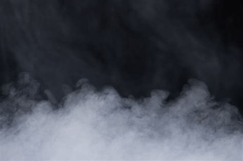 검은 배경에 흰 연기와 안개가 짙은 푹신한 퍼프 추상적인 연기 구름 초점이 흐려진 움직임 공기 중에 펄럭이는 기계 드라이 아이스 파리에서 연기가 나고 효과 질감 개념에 대한