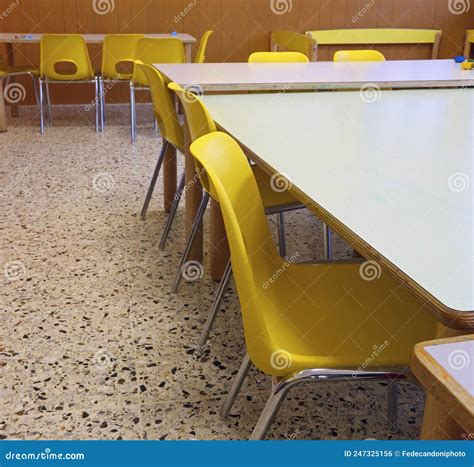 School Classroom Of A School With Small Yellow Chairs And Tables Stock