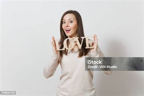 아름 다운 젊은 갈색 머리 재미 가벼운 캐주얼 옷 흰색 배경에 나무 말씀 사랑을 들고 여자를 웃 고 광고에 대 한 공간을 복사 합니다 성 발렌타인의 날 또는 국제 여성의 날