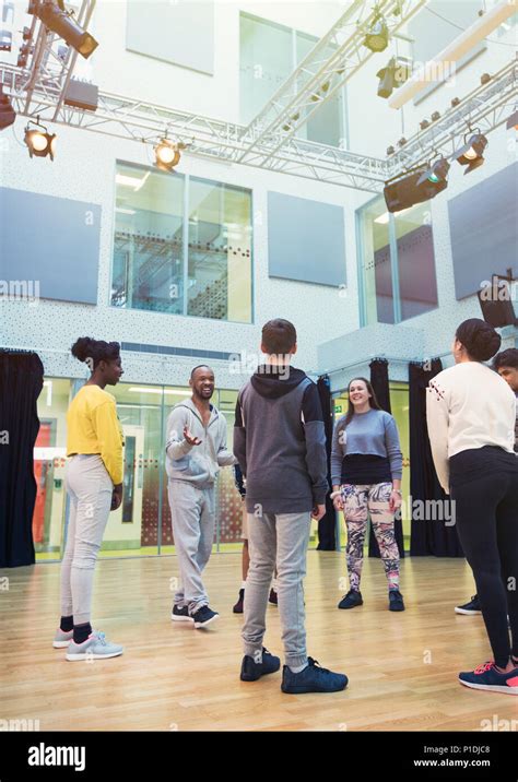 Teenage Students Listening To Male Instructor In Dance Class Studio