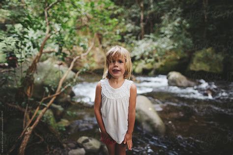 Cute Young Girl Having To Go Pee Outside Near River By Stocksy