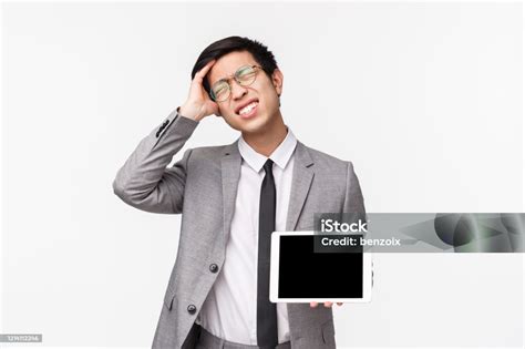 부끄럽거나 건망증 젊은 아시아 사업가의 허리 업 초상화 뭔가를 잊어 버린 중요한 일에 대해 기억 디지털 태블릿 화면을 보여주는