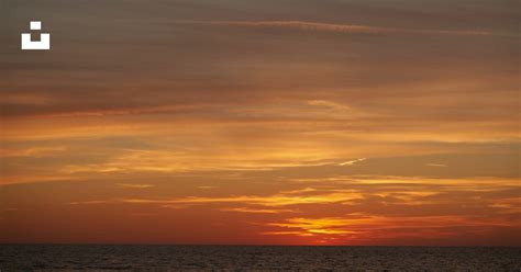 구름 낀 날 바다 위로 해가 지고 있습니다 사진 Unsplash의 무료 회색 이미지