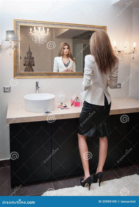 Sensual Elegant Woman In Office Outfit Looking Into A Large Mirror