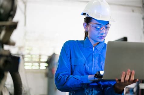 Premium Photo Female Engineer Programming Robotic Arm Machine For System Welding With Laptop