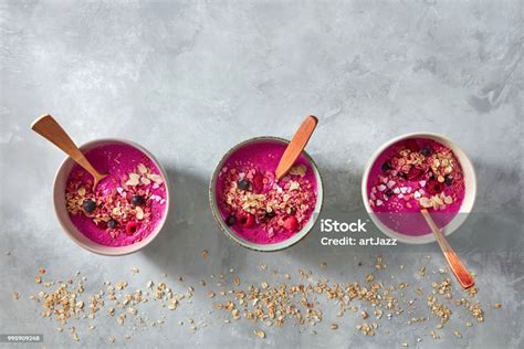 라스베리와 맛 있는 갓된 근대 스무디 회색 콘크리트 바탕에 숟가락으로 접시에 그 라 놀라와 참 깨 씨앗 상위 뷰 비트에 대한