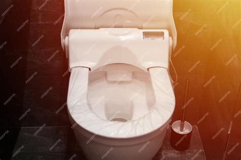 자동 필름 교체 시스템 림 스마트 현대식 배관 플레어가 있는 공중 화장실 화장실의 변기 변기 위생 시스템 변기 가장자리에 있는 일회용 커버 패드 프리미엄 사진