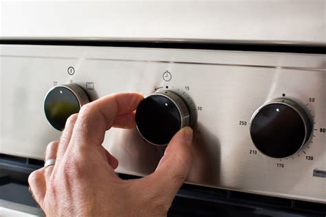 Premium Photo Man Regulates The Temperature Of The Oven
