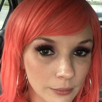 A Woman With Bright Red Hair And Large Hoop Earrings On Her Head