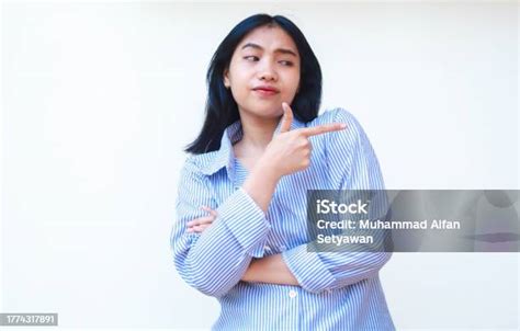 캐주얼 줄무늬 셔츠를 입고 혼란스러워하는 아시아 여자 손가락으로 빈 공간을 가리키고 선택 생각 고립 된 흰색 배경 위에 서있는 20 24세에 대한 스톡 사진 및 기타 이미지