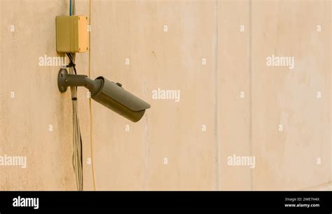 Cctv Security Camera And Associated Wires Mounted Under Window On Side