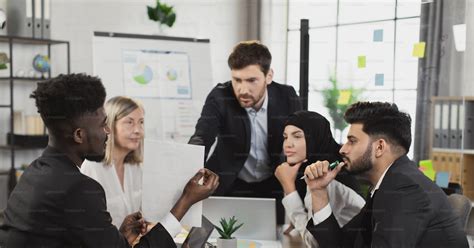 유능한 재무 분석가 팀이 브레인스토밍을 위해 회의실에 모입니다 정장을 입은 다인종 남녀들이 공동 프로젝트의 사업 계획을 논의하고 있다 사진 Unsplash의 회사 이미지