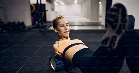 체육관에서 스포츠 훈련을 위해 워밍업하는 폼 롤러를 사용하는 장애가 있는 동기 부여 운동 선수 사진 Unsplash의 체육관