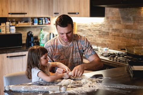 아버지와 딸이 부엌에서 함께 반죽을 준비하고 실제 집에서 정통 가족 요리를합니다 부성과 가족 주말 개념 아이 소녀를 가르치는 아버지는 쿠키를 준비합니다 L 2 3 살에 대한