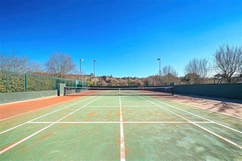 Empty Tennis Court Under Blue Sky Premium Ai Generated Image